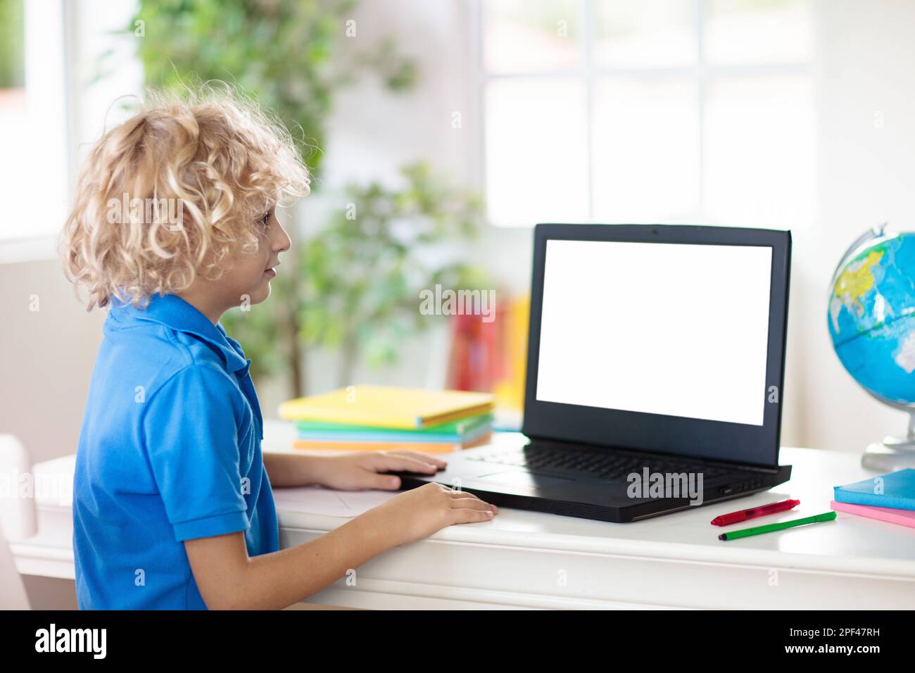 School child doing homework. Empty laptop screen. Blank copy space on ...