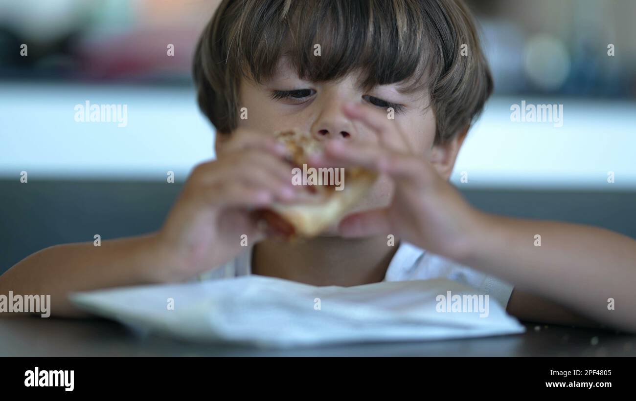 Little boy eating sandwich. Child taking a bite of bread. Kid eats ...