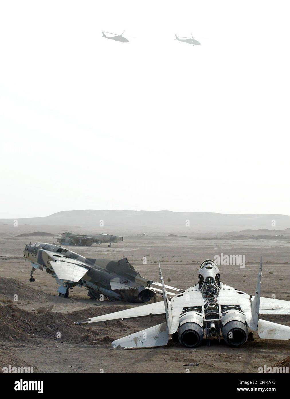 U.S. Blackhawk helicopters fly above looted Iraqi Air Force jet ...