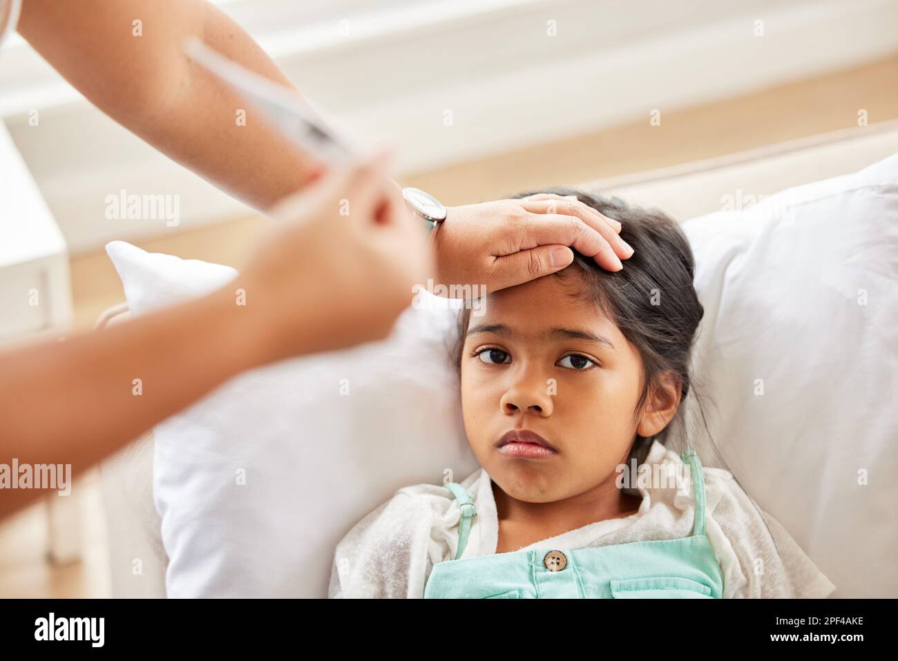 Sick little girl looking weak while resting on the sofa and having her ...
