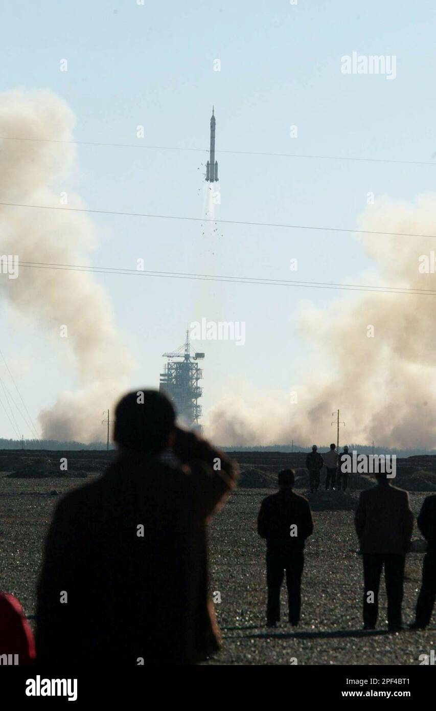 People watch China's first manned spacecraft Shenzhou 5 lift off near ...