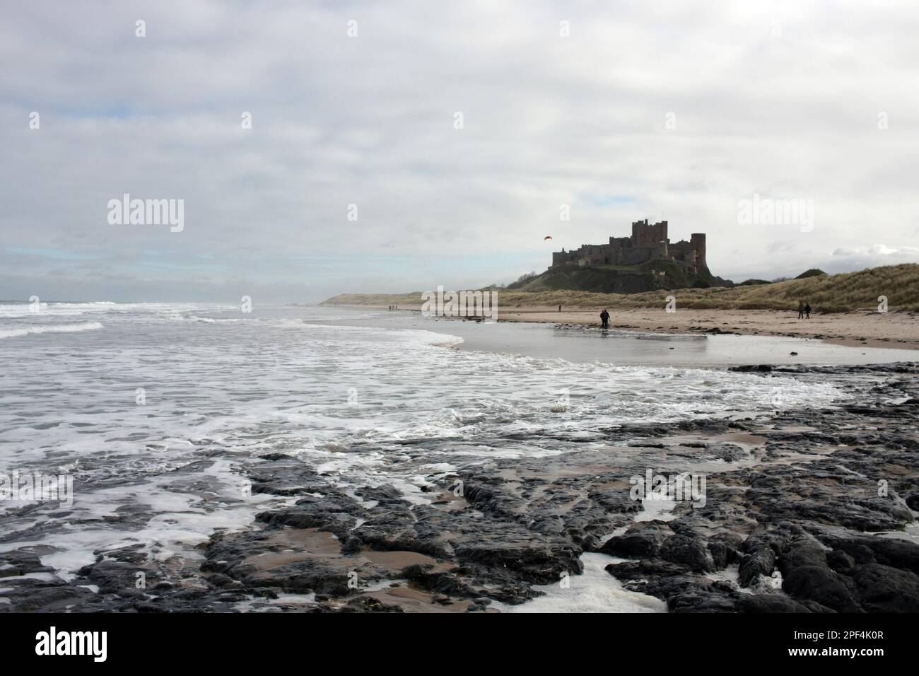 Bamburgh Beach below the Castle, the imposing medieval castle and ...