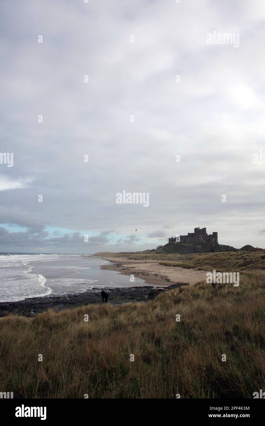 Bamburgh Beach below the Castle, the imposing medieval castle and ...