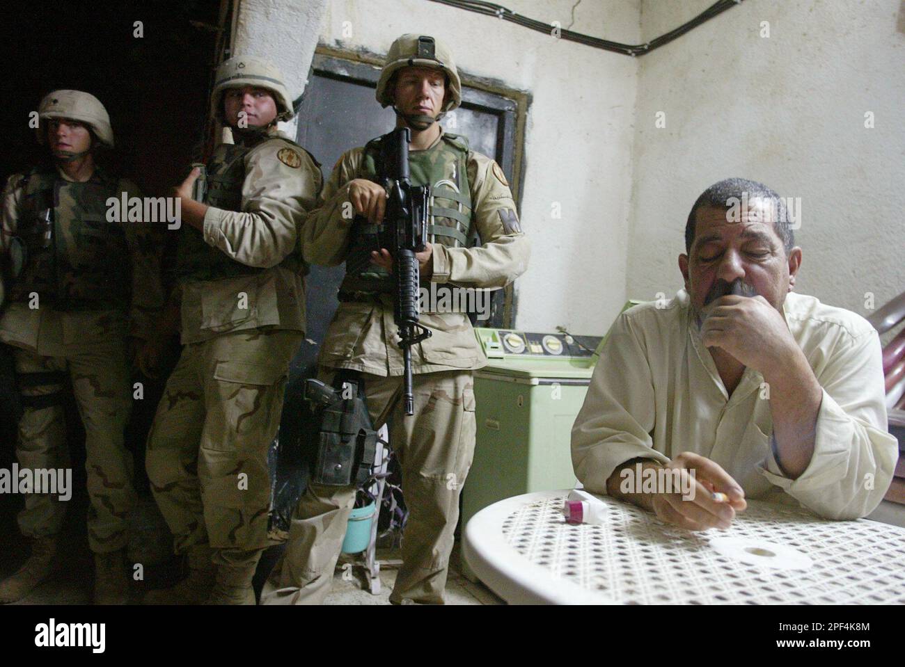 Members of the U.S. Army's 720th Military Police Battalion guard a man ...