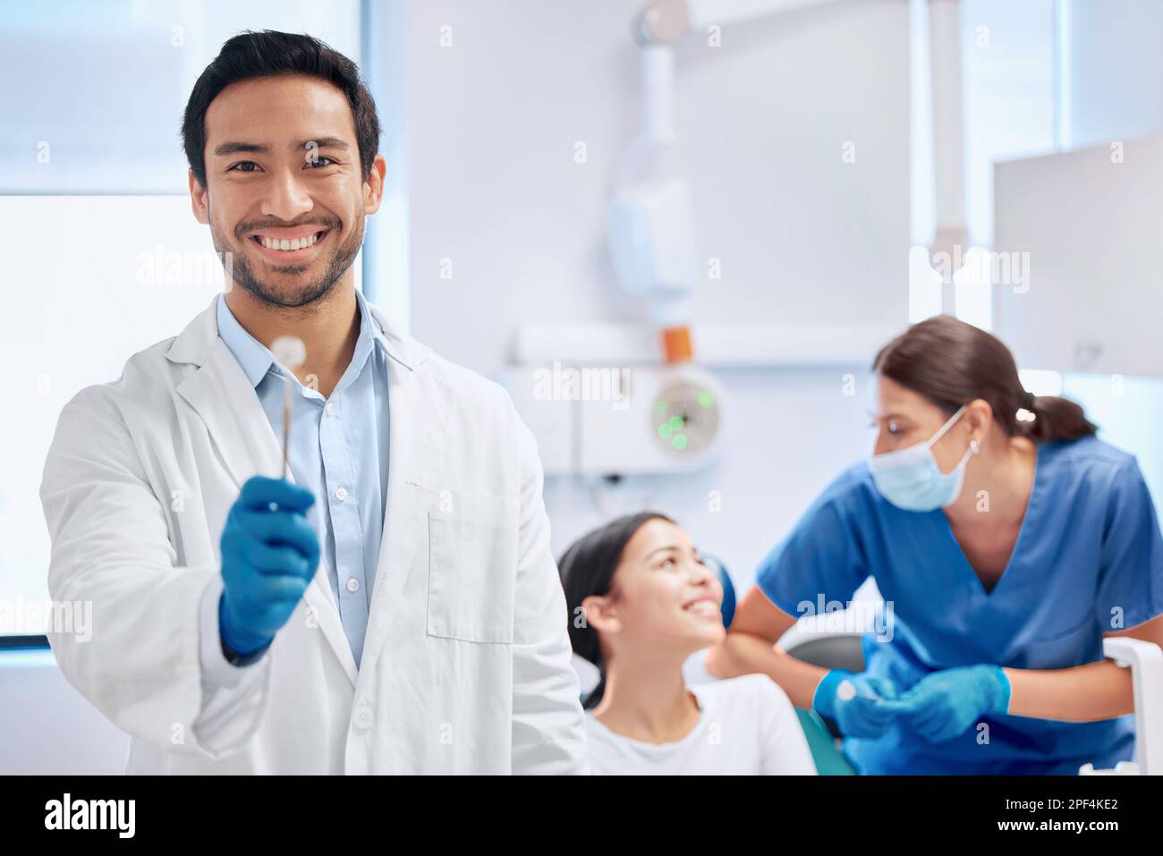 Providing his patients with high grade tools. a young dentist holding ...