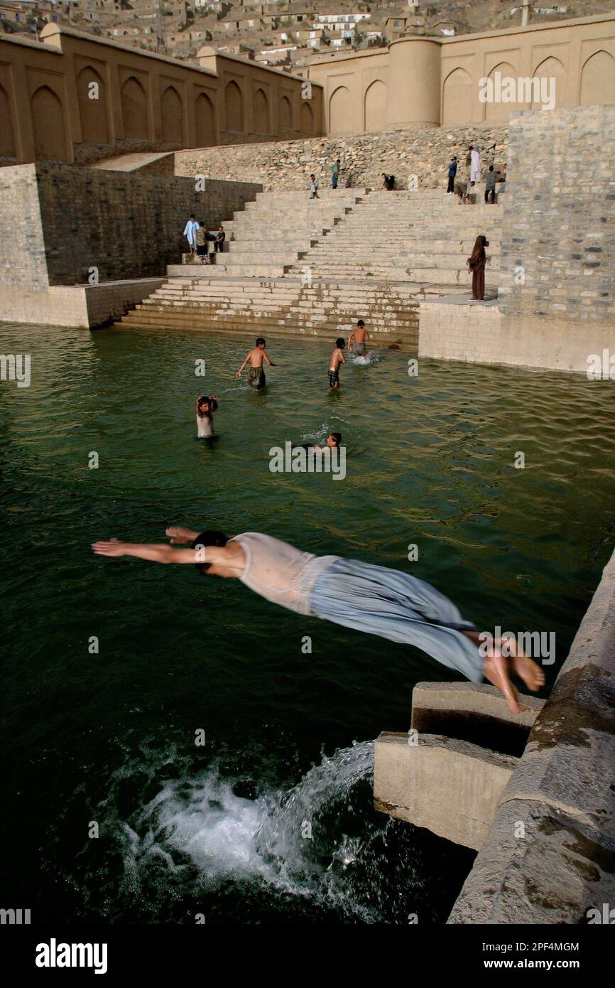 A young Afghan boy dives into a swimming pool at Babur Shah Gardens in ...