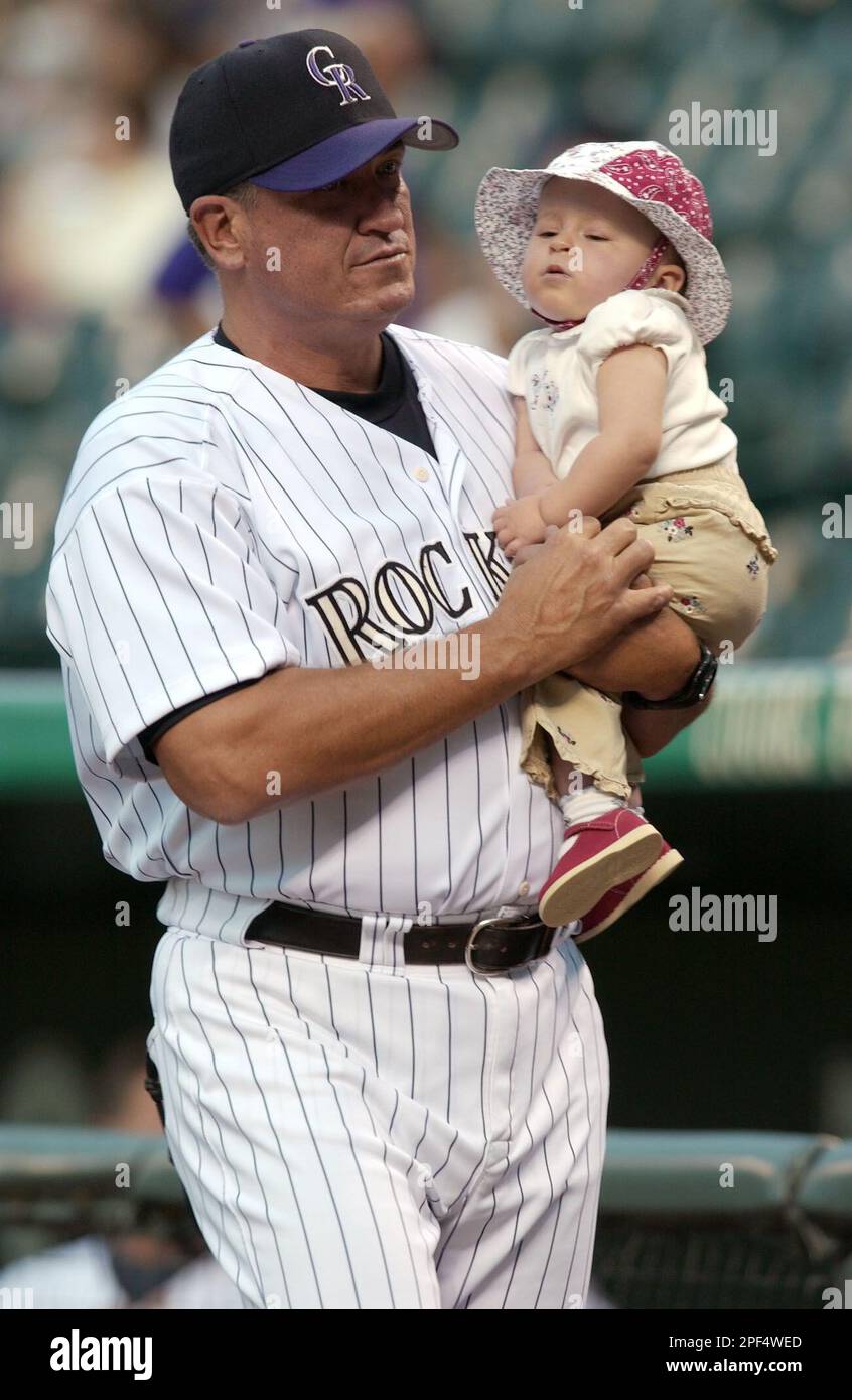 Colorado Rockies manager Clint Hurdle, left, carries his year-old ...