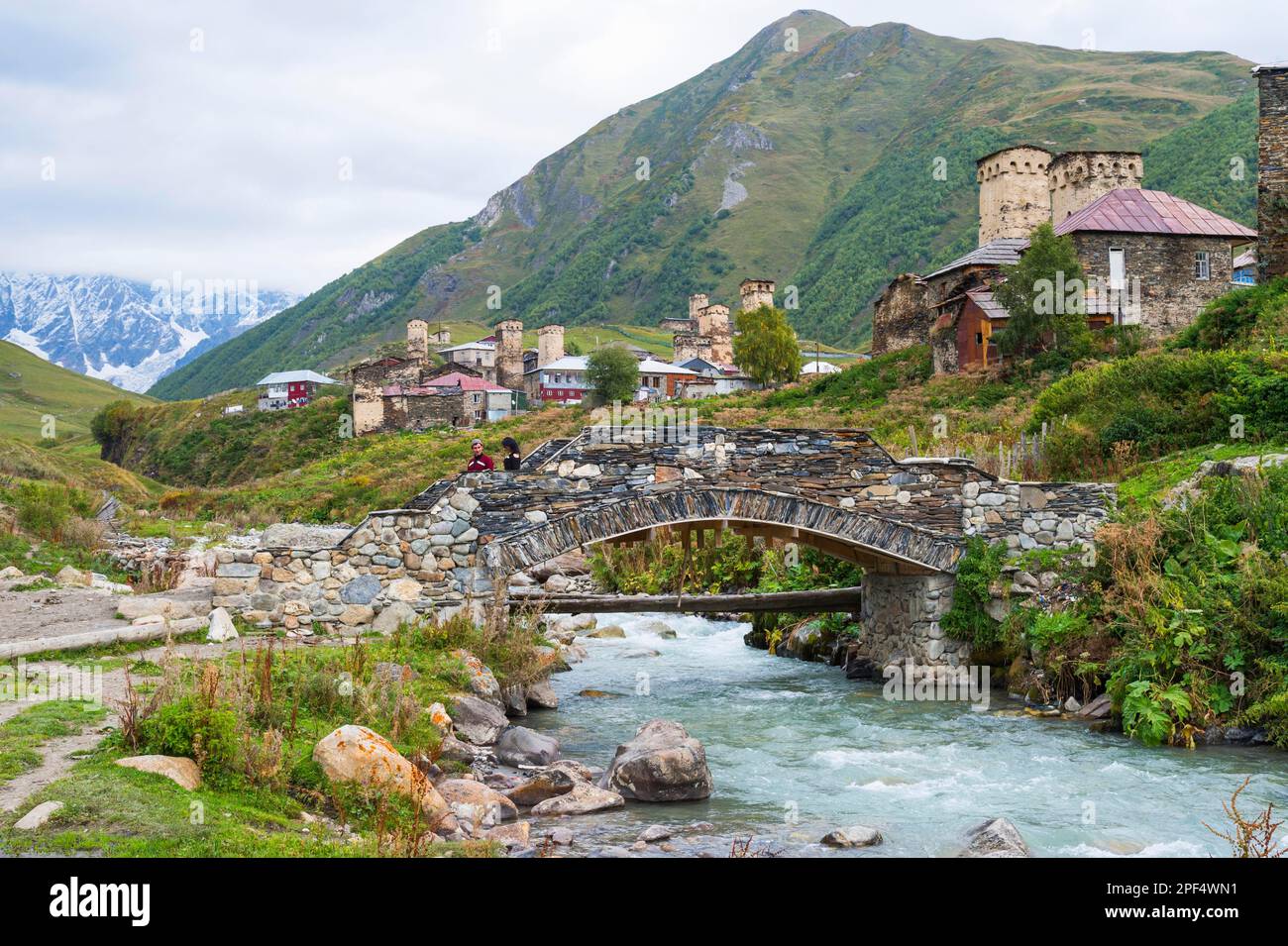 Georgian couple from a folklore group on a stone bridge outside the ...