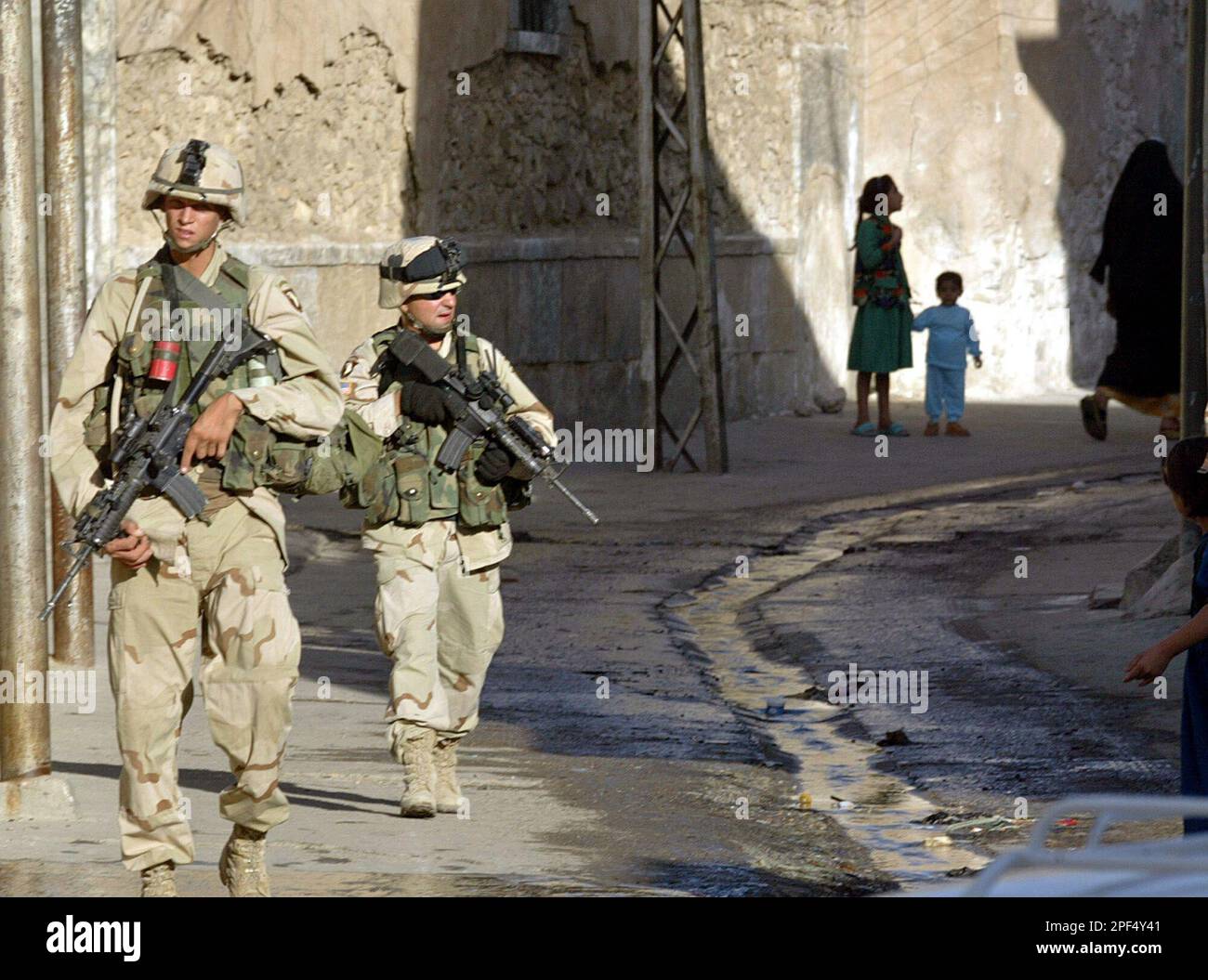 U.S. Army soldiers of the 101st Airborne Aivision patrol a street in ...
