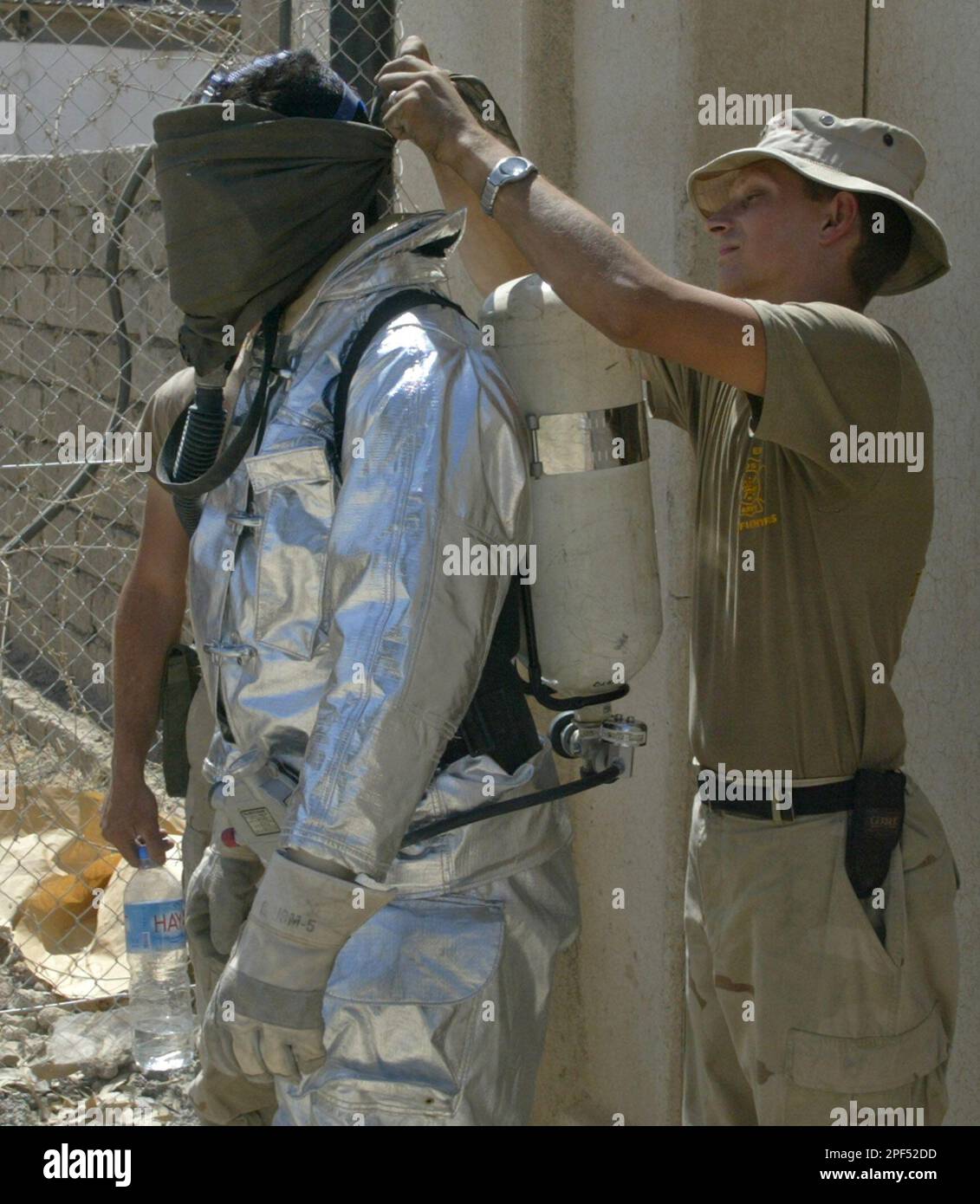 A U.S. Army soldier trains a new Iraqi fire fighter at a U.S. Army base ...