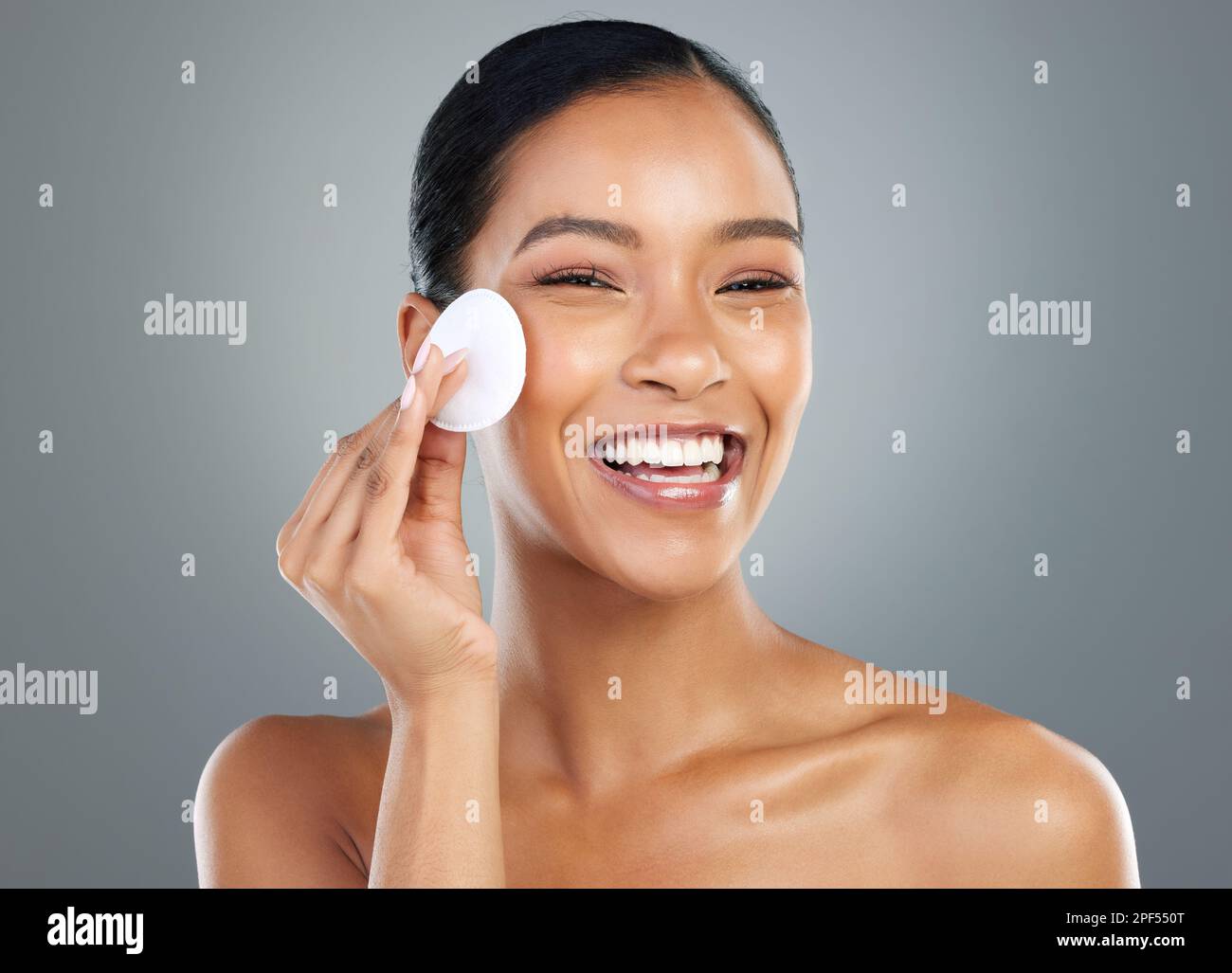 Let the skin breathe. a beautiful young woman using a cotton pad to ...