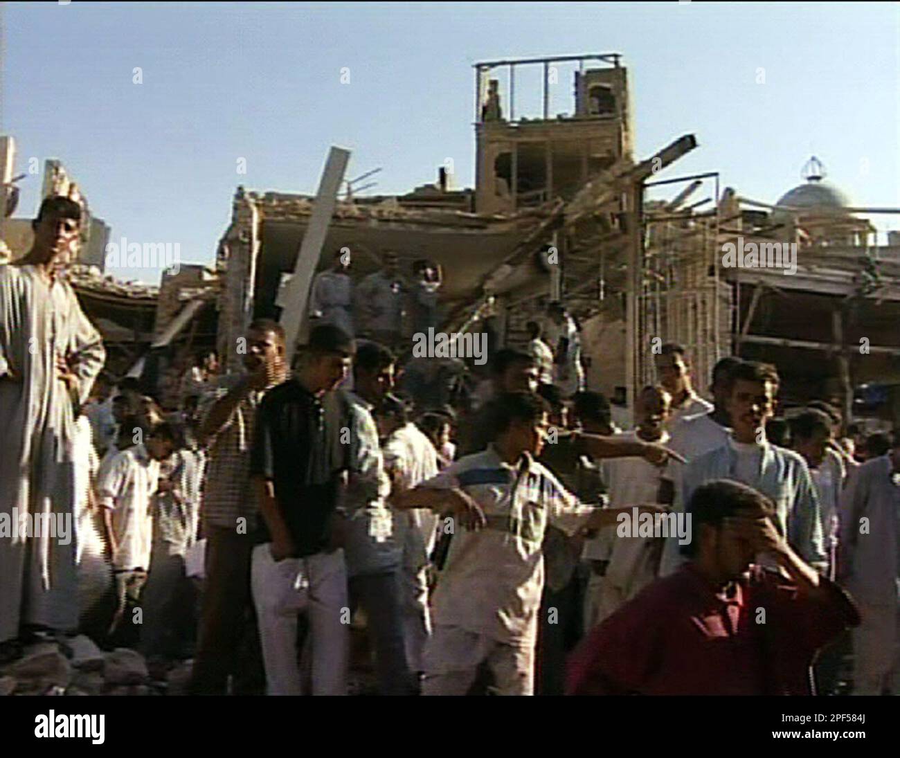 People gather outside damaged buildings in this image from television ...
