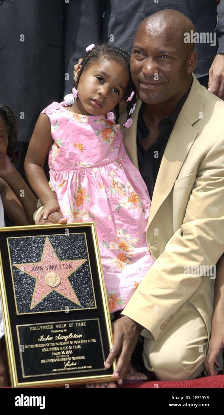 Director John Singleton holds his daughter, Cleo, Tuesday, Aug. 26 ...