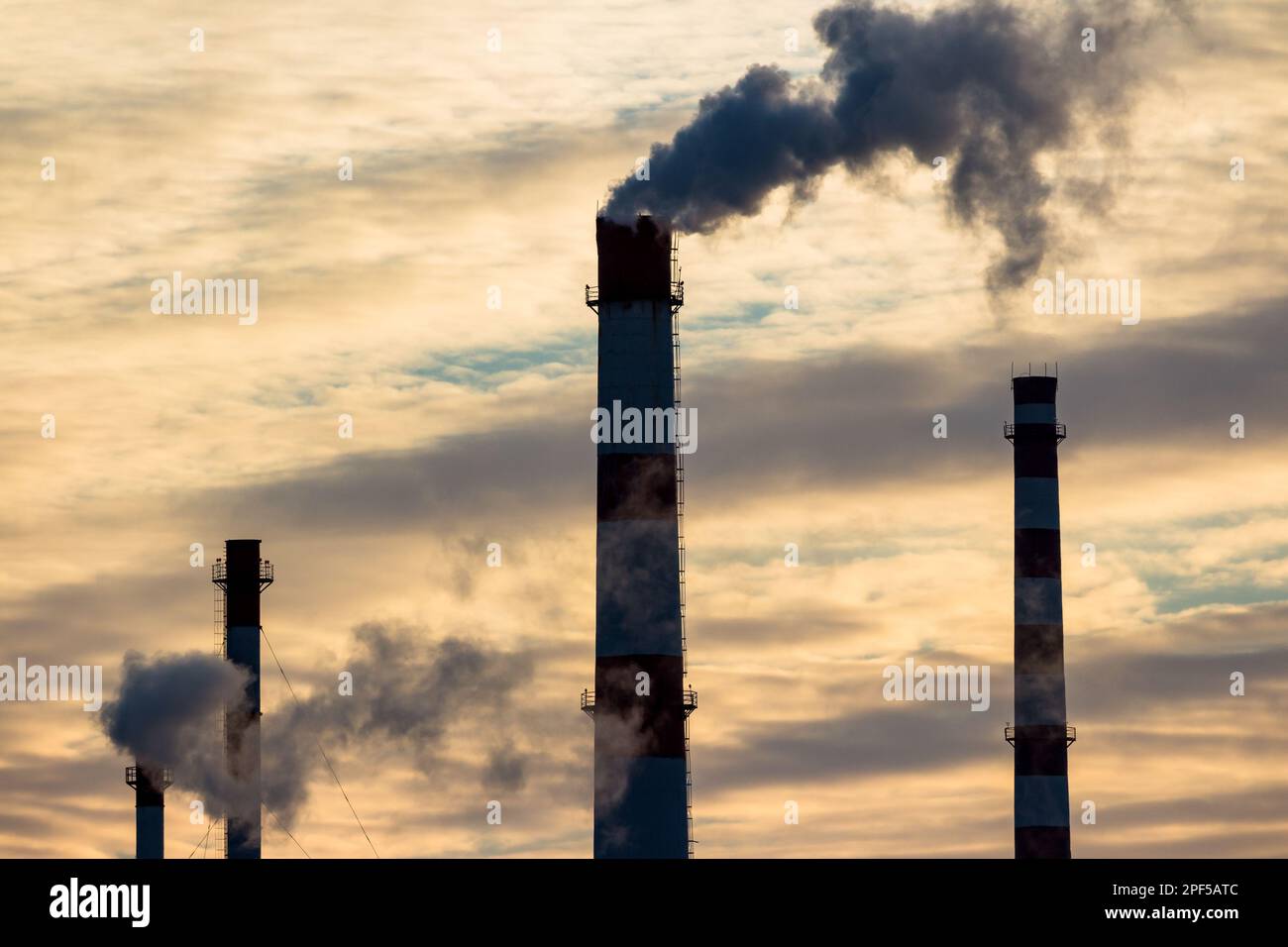 Industrial landscape with a view of tall chimneys releasing puffs of ...