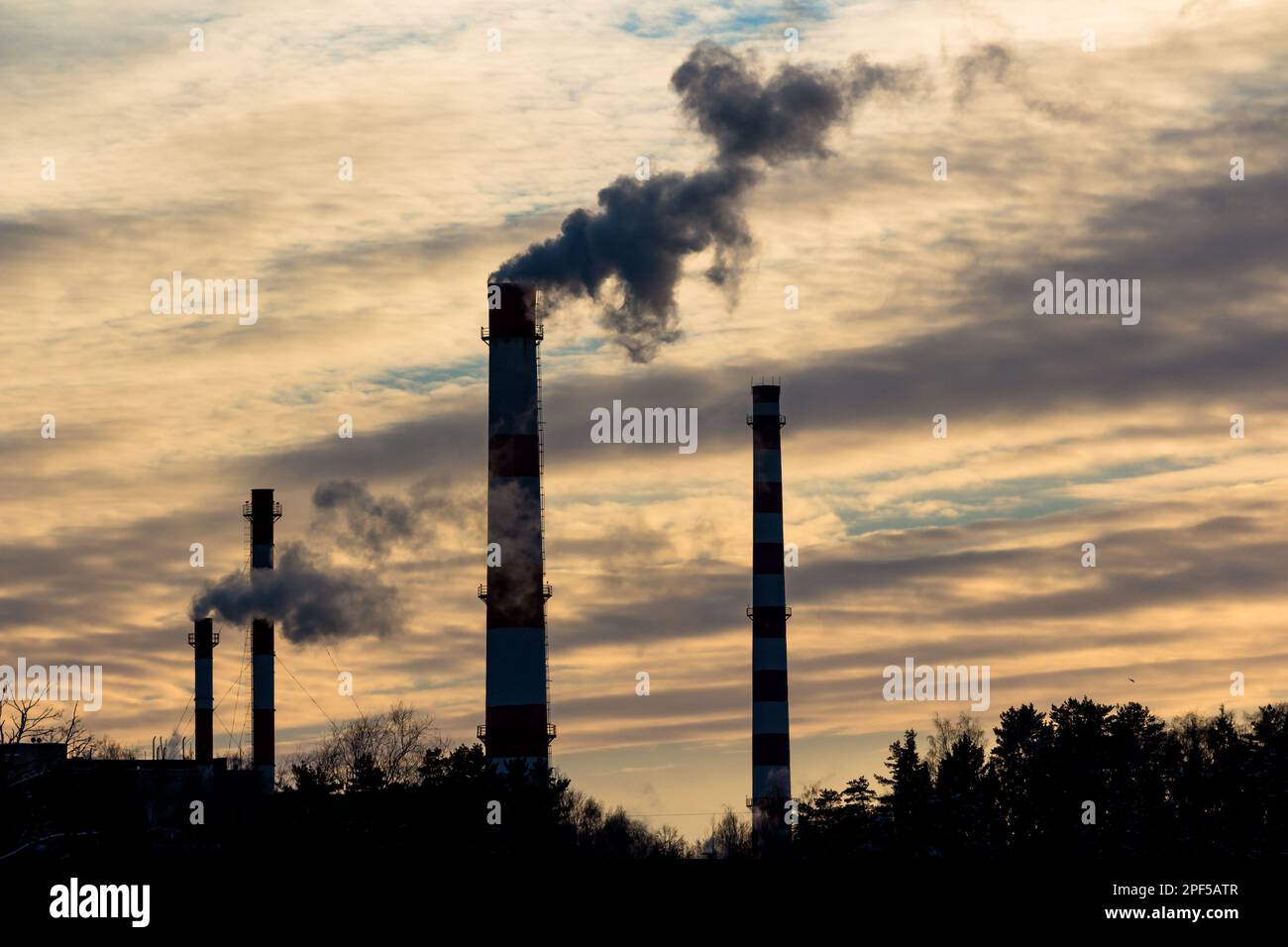 Industrial landscape with a view of tall chimneys releasing puffs of ...