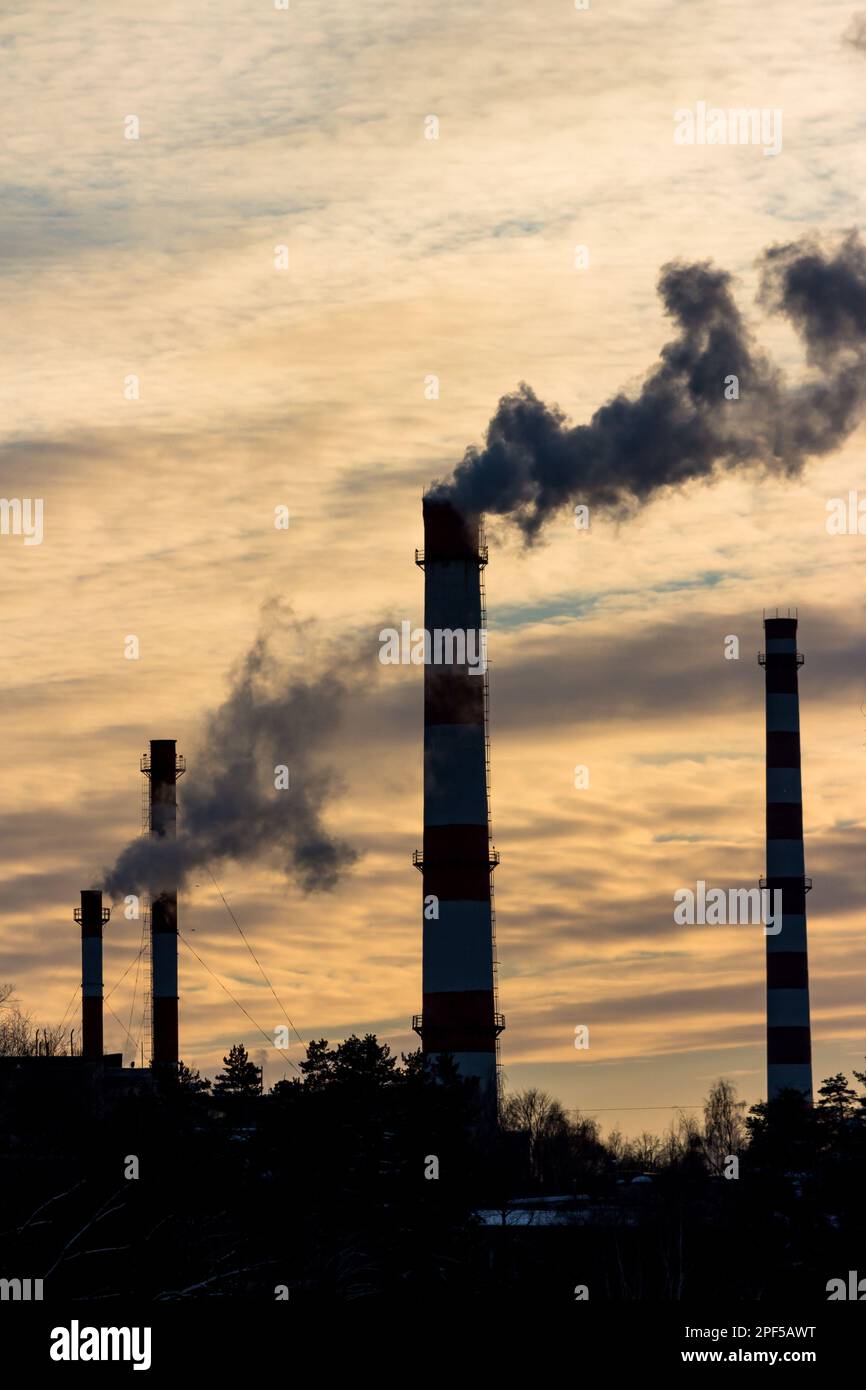 Industrial landscape with a view of tall chimneys releasing puffs of ...