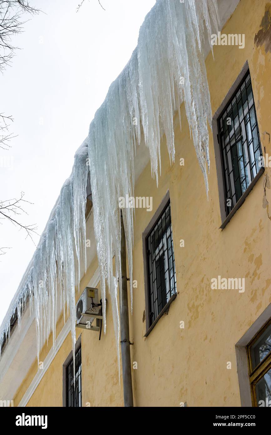 Vertical view of large and sharp icicles hanging from the roof of a ...