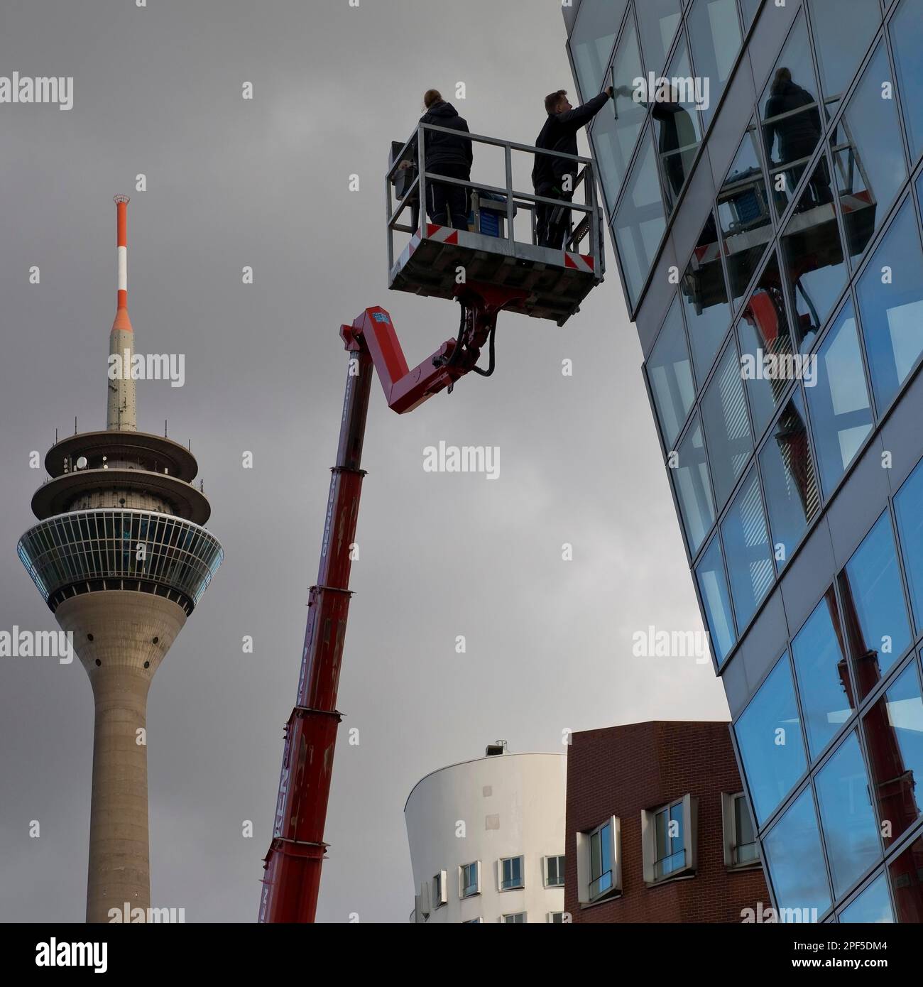 Building cleaner on a working platform with extended crane with Rhine ...