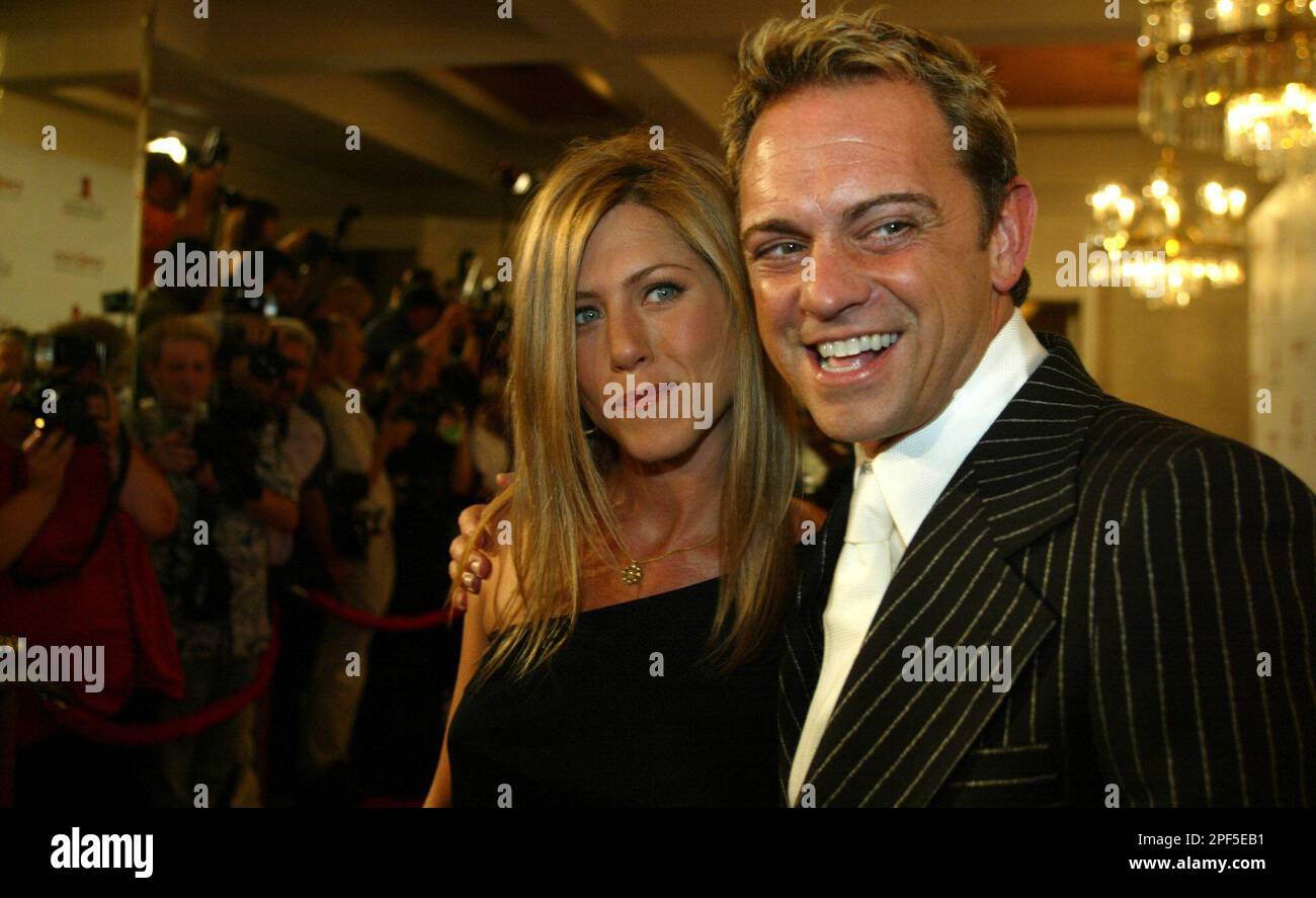 Jennifer Aniston, left, poses for a photo with Dan Kough, executive ...