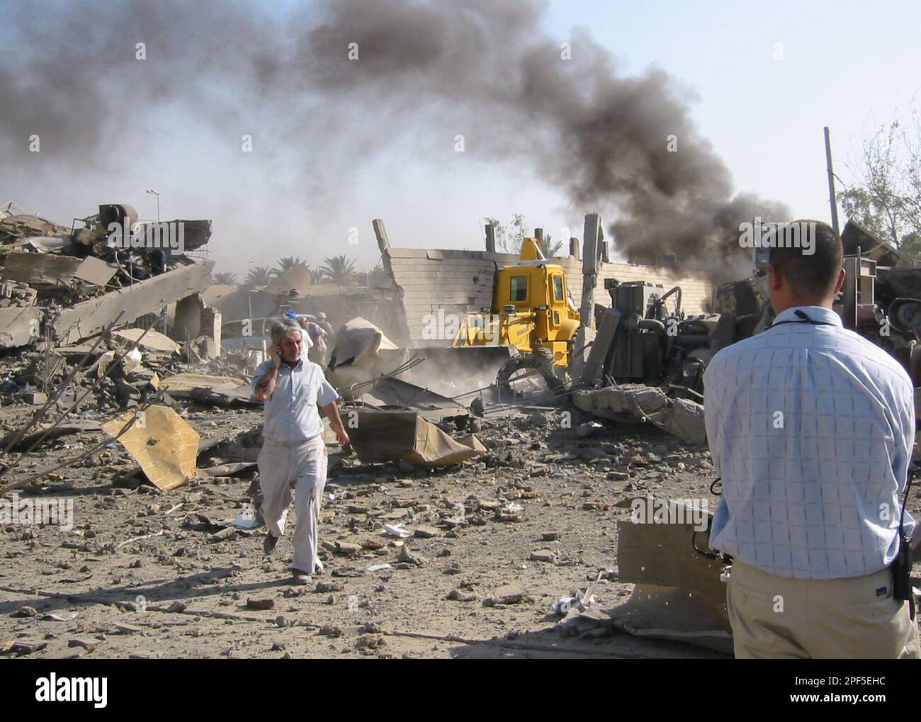 Employees and security stand amid debris and fire at the United Nations ...