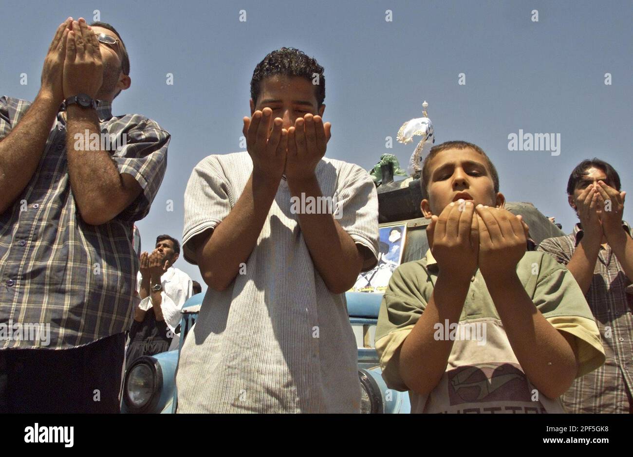 Iraqis pray during Friday prayers at the poorest district of Baghdad ...
