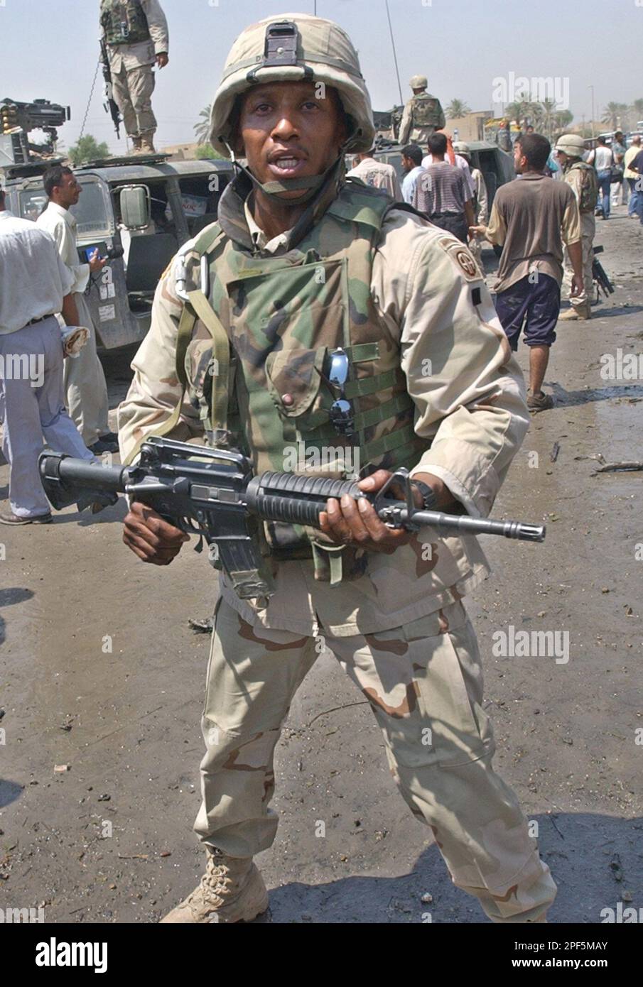 U.S. troops prepare to push back onlookers as they seal off the road in ...