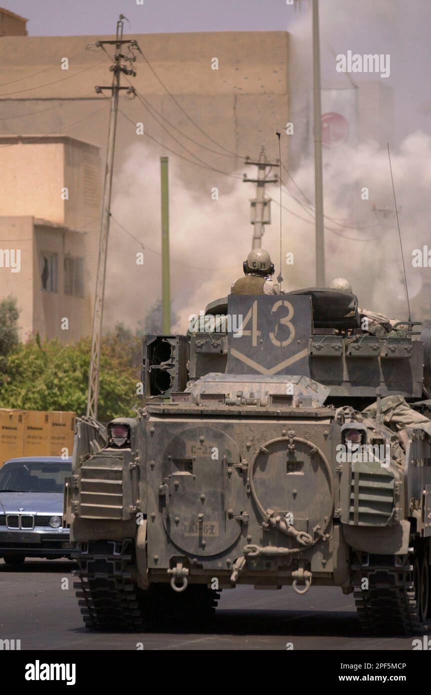 A U.S.Army Bradley fighting vehicle fires rounds into a building after ...