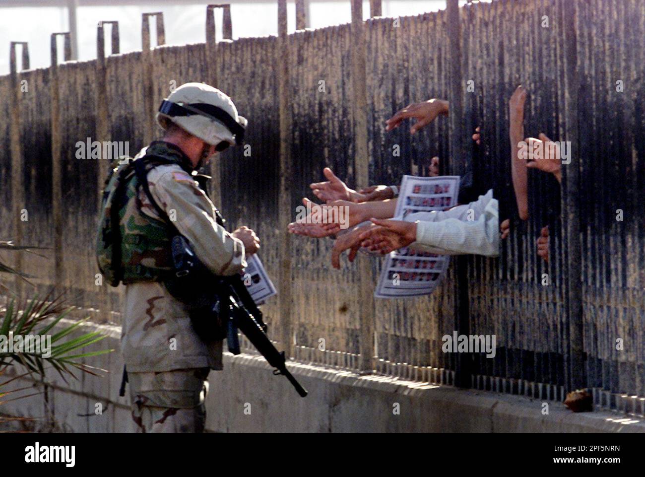A U.S. soldier distributes the latest posters of wanted persons from ...