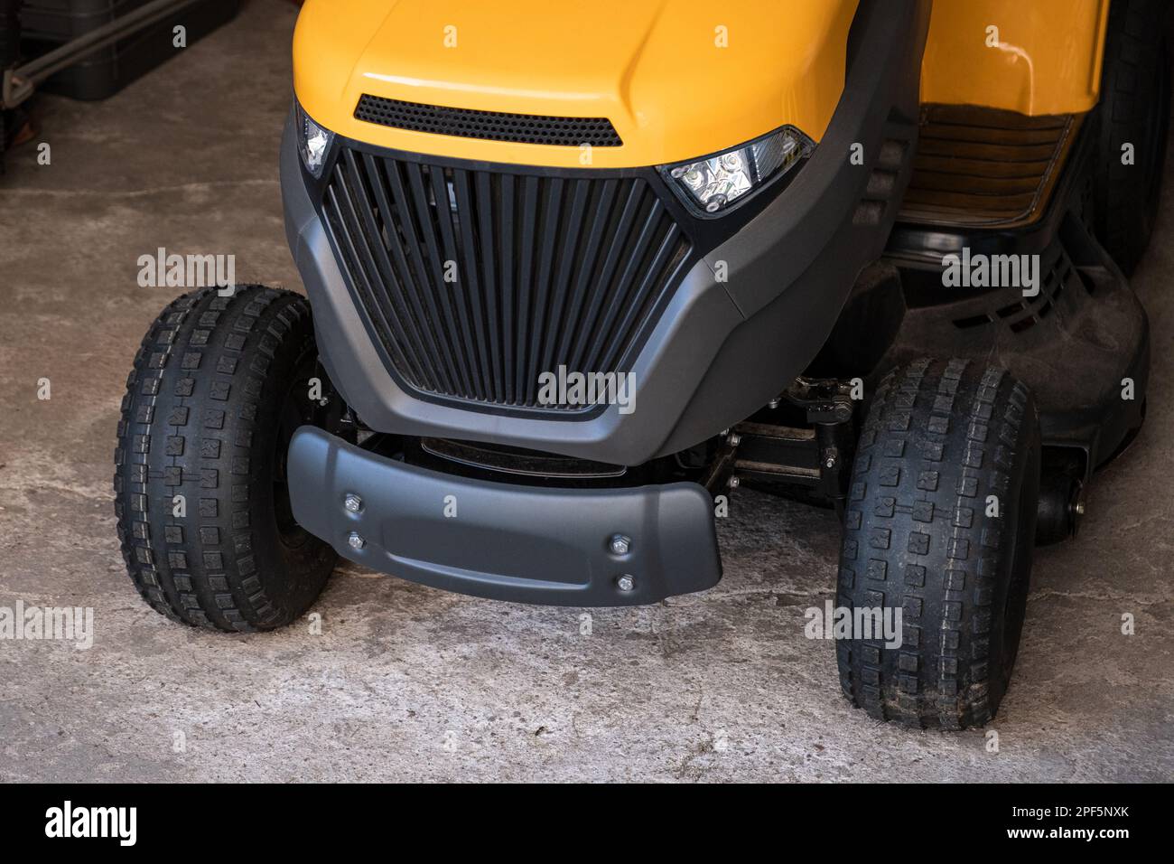 Details of a generic yellow lawn mower minitractor for garden work ...
