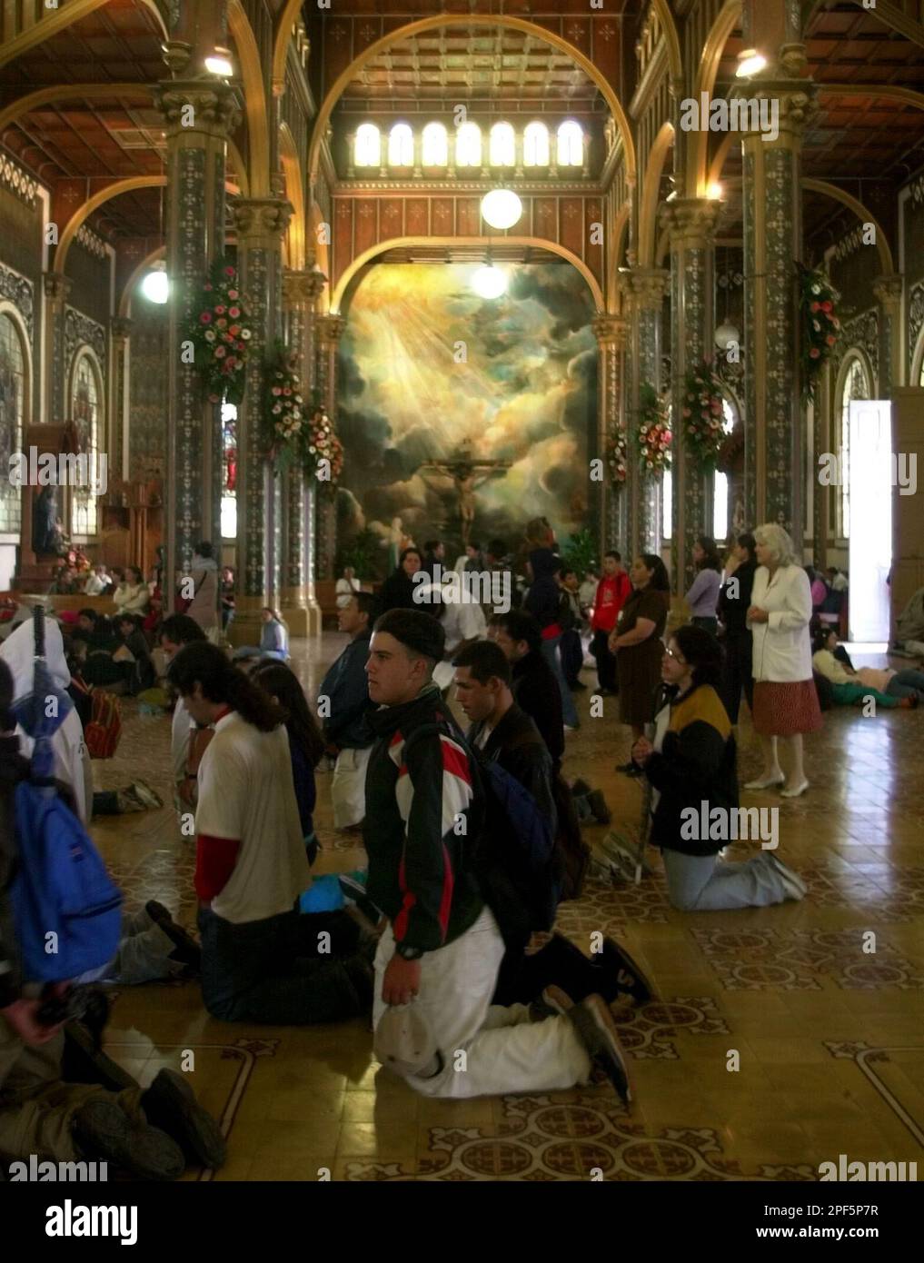 Costa Rican Catholics make their way to the altar on their knees inside ...
