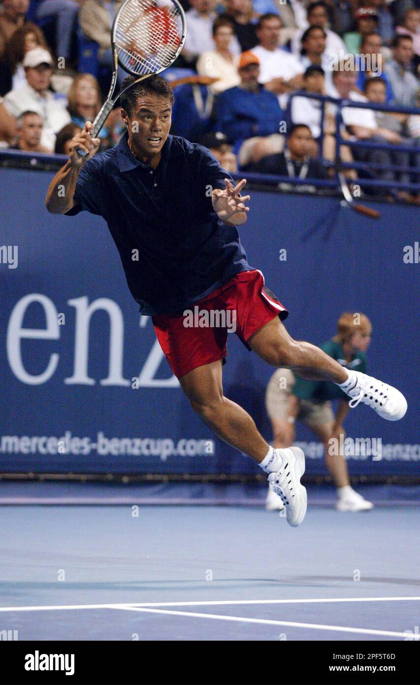 Cecil Mamiit flies through the air while hitting the ball back to ...