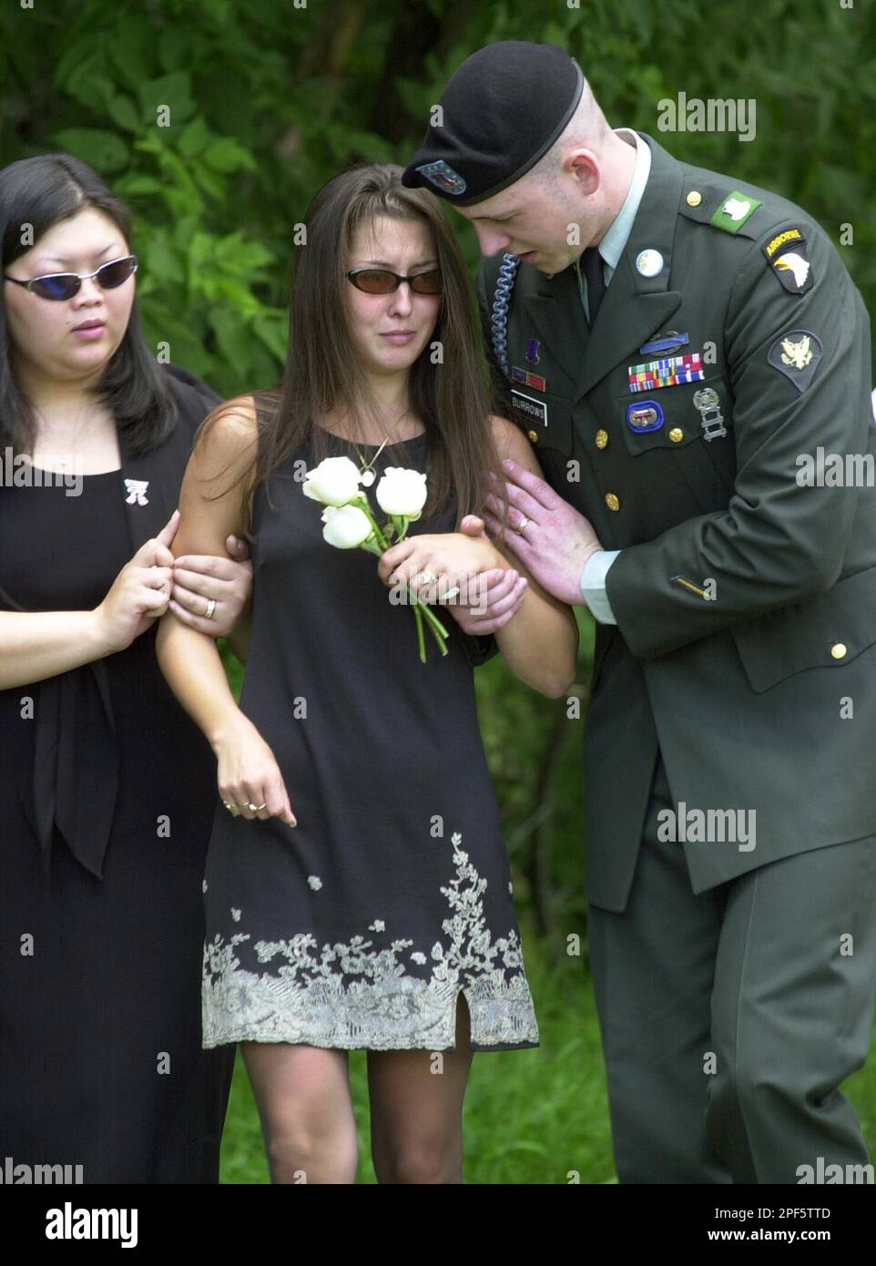 The wife of Army Sgt. Justin Garvey, Katie, center, is comforted ...