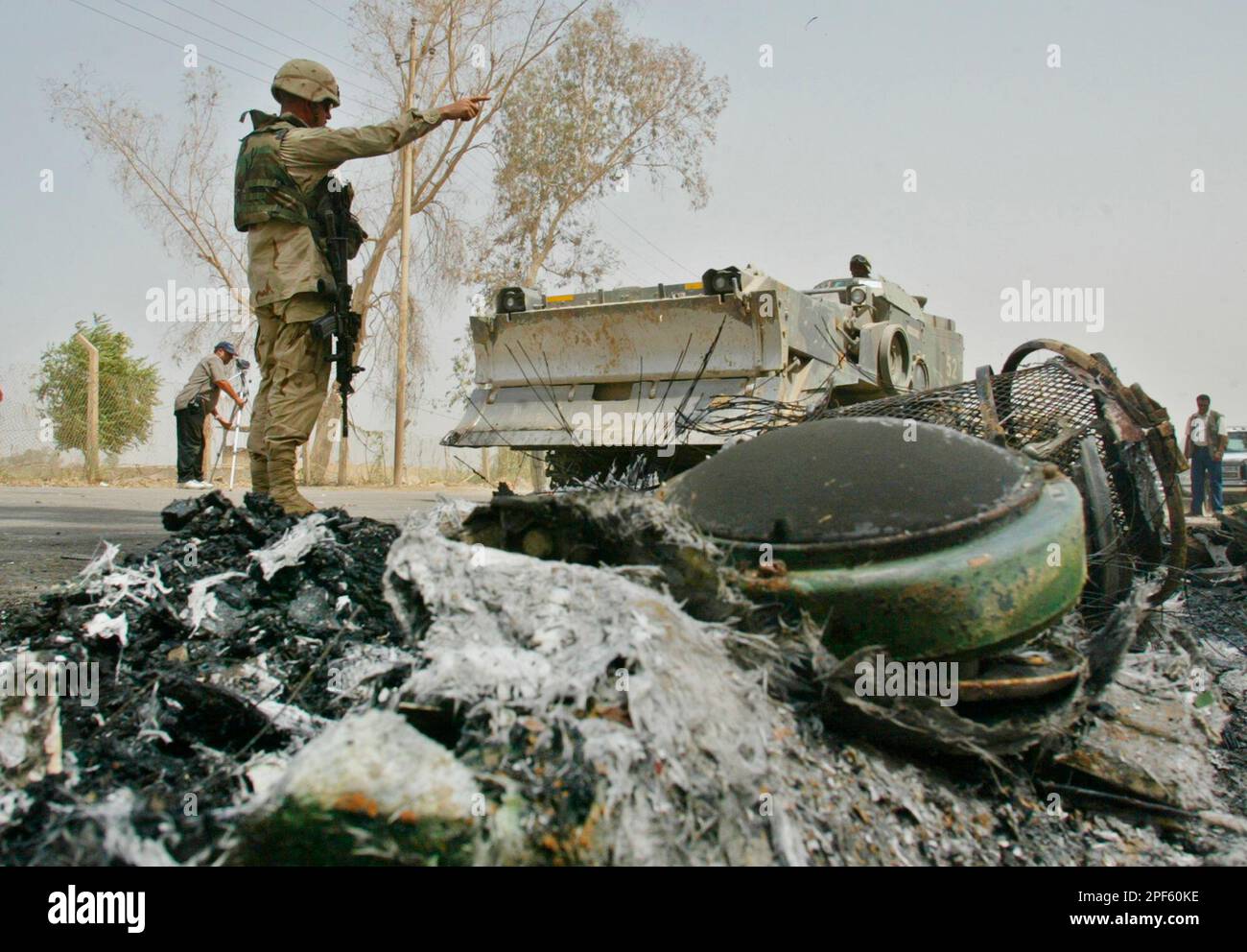 A U.S. soldier from the 1st Armored Division directs cleaning up ...