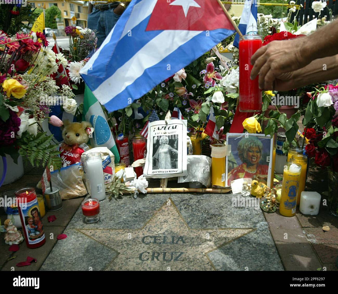 A person places a Cuban flag at the memorial site of Celia Cruz on her ...