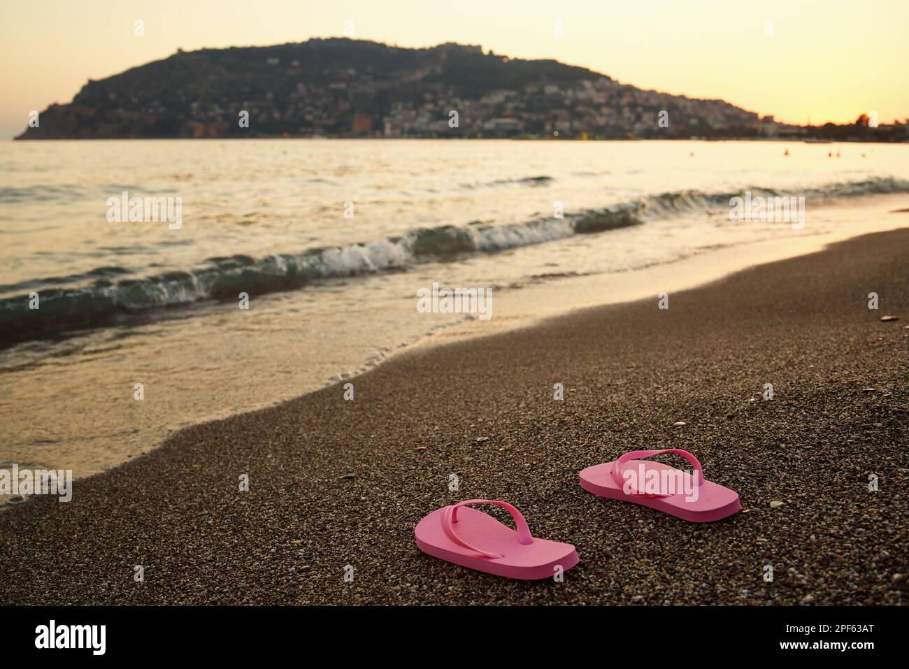 Pink flip flops on the beach at the seaside at sunset Stock Photo - Alamy