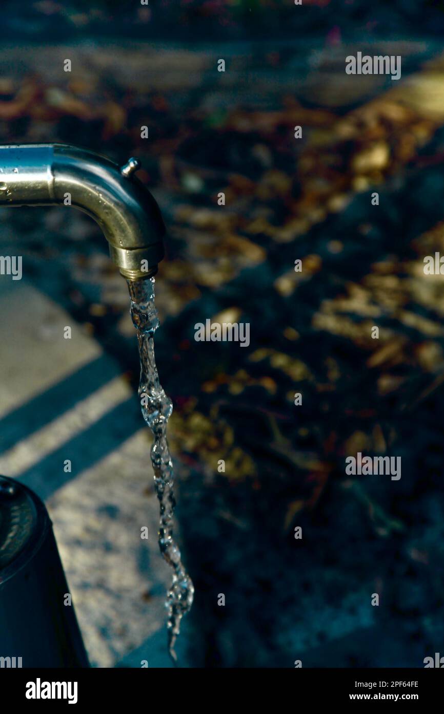 A large silver tube with a spigot ejecting a steady stream of water ...