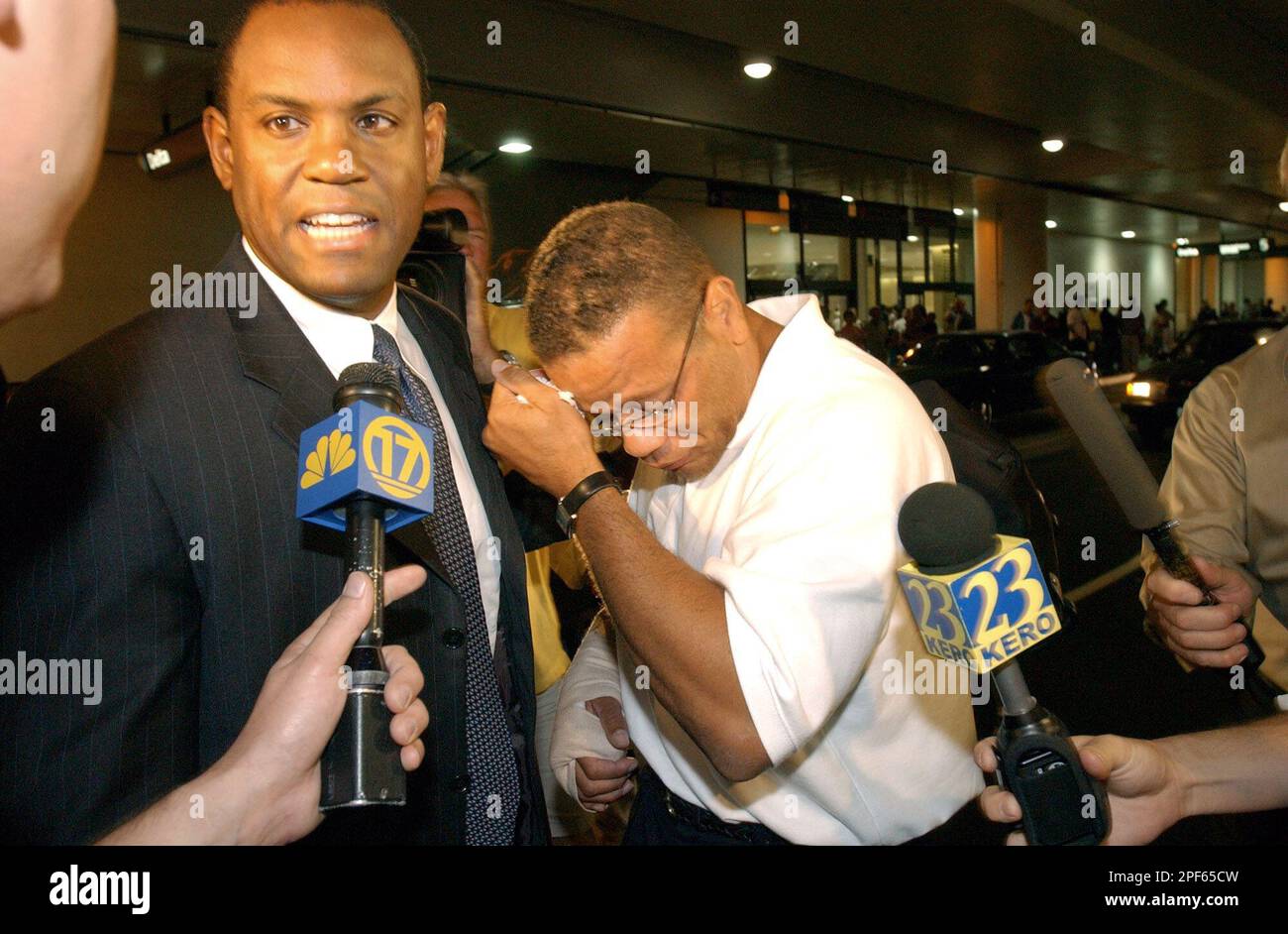 Vincent Brothers, right, shields himself from television cameras after ...