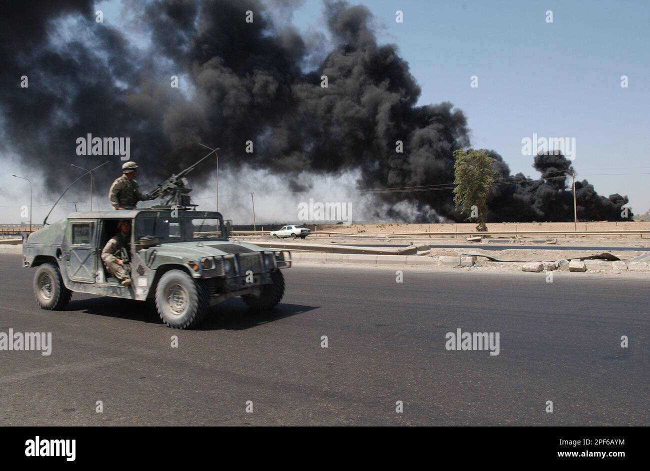 US soldiers on a humvee patrol a street on the oustkirts of Baghdad ...