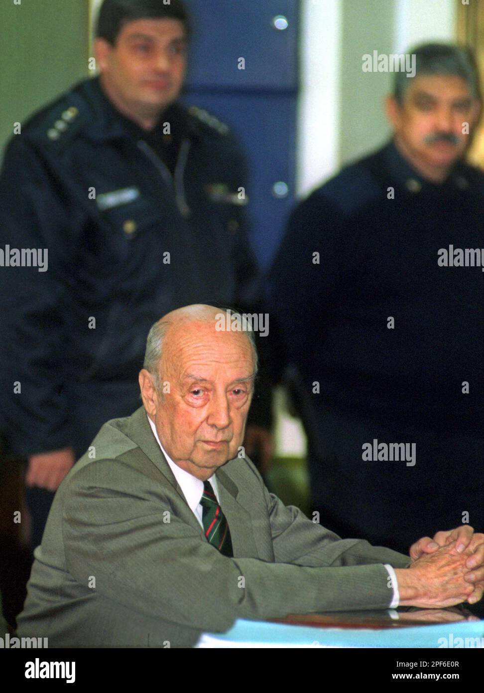 Former Army Cmdr. Guillermo Suarez Mason is guarded by police officers ...