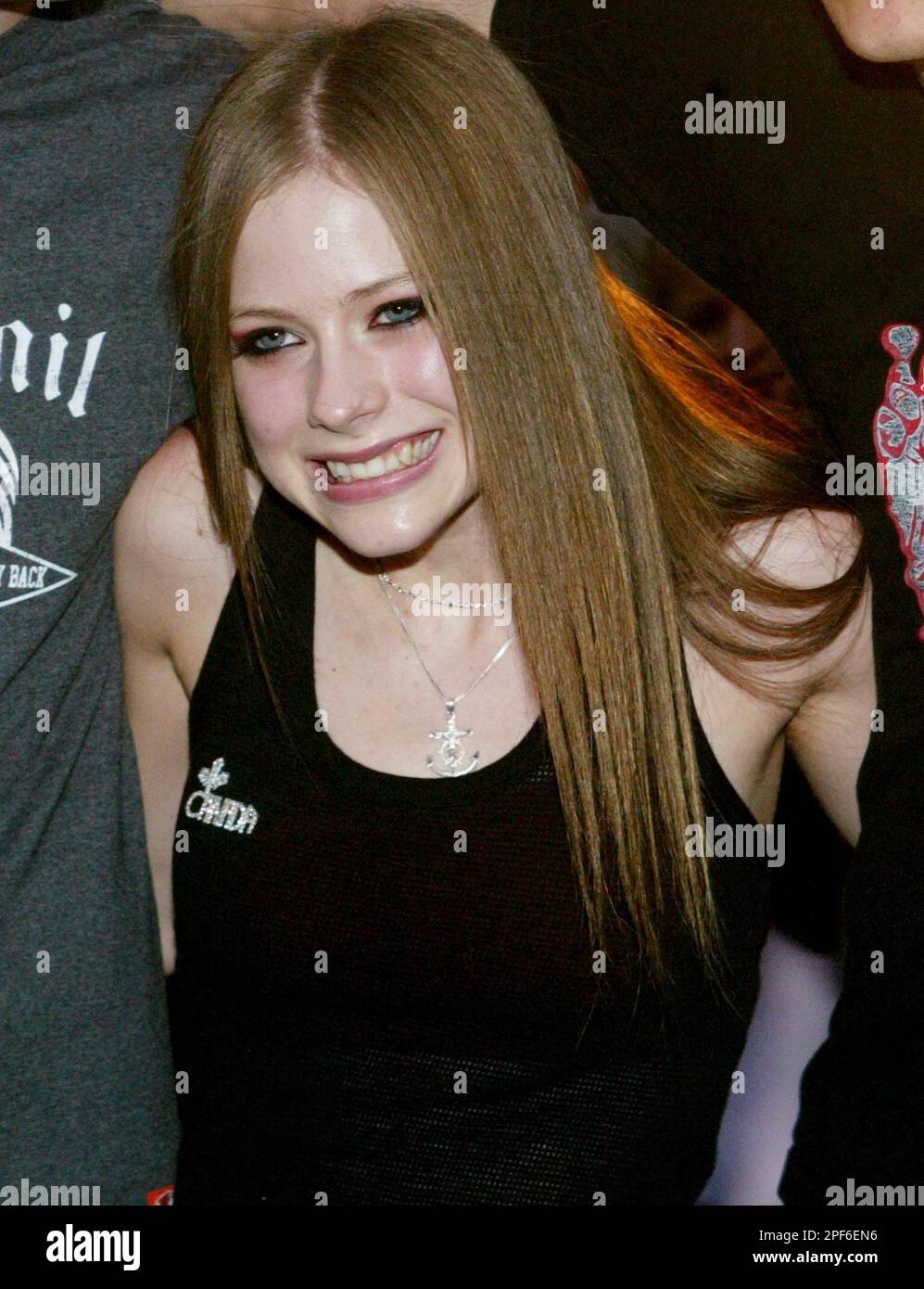 Avril Lavigne smiles as she as she squeezes between bandmates as she ...