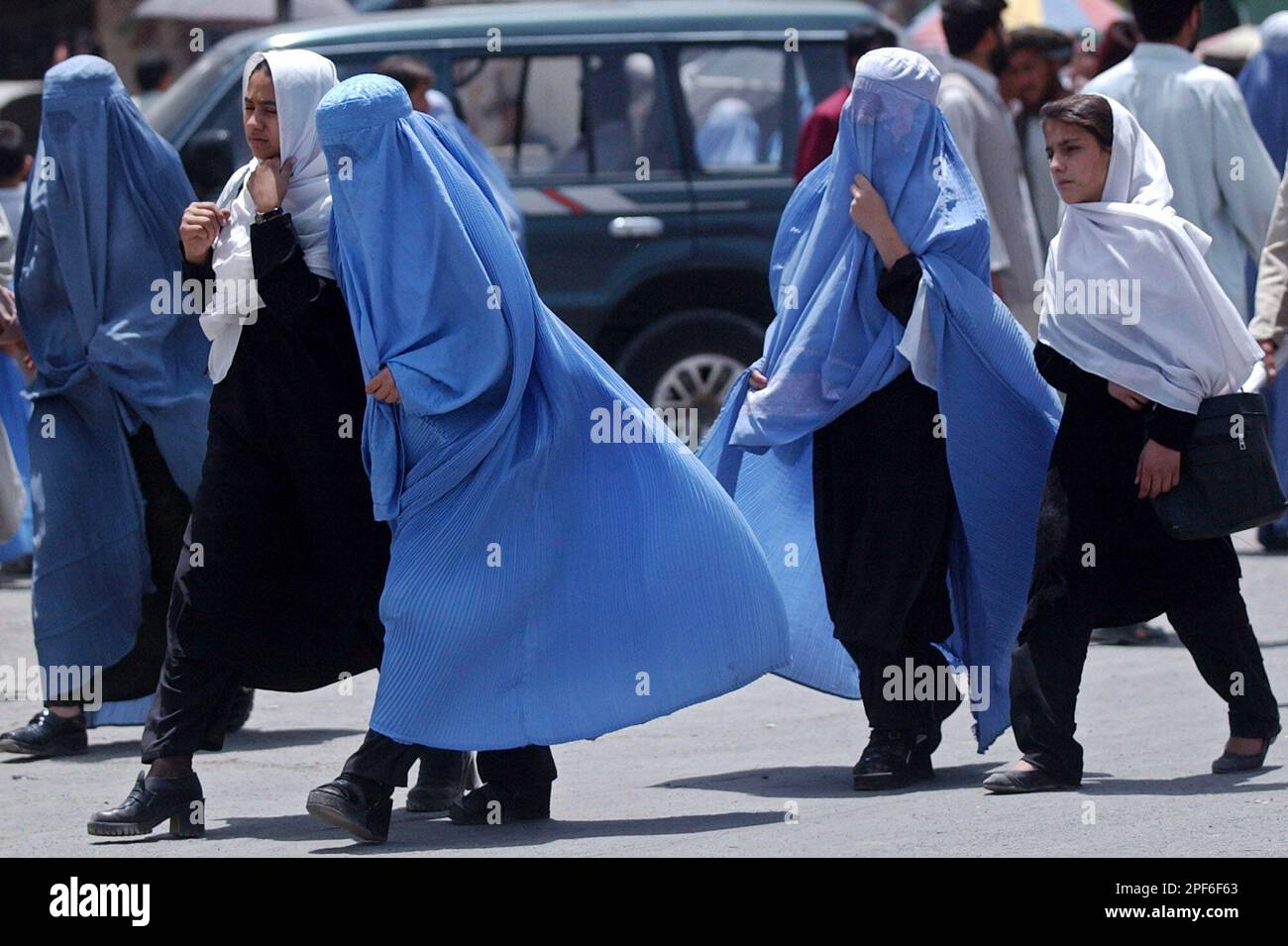 Unveiled Afghan schoolgirls walks with burqa-clad women in Kabul ...