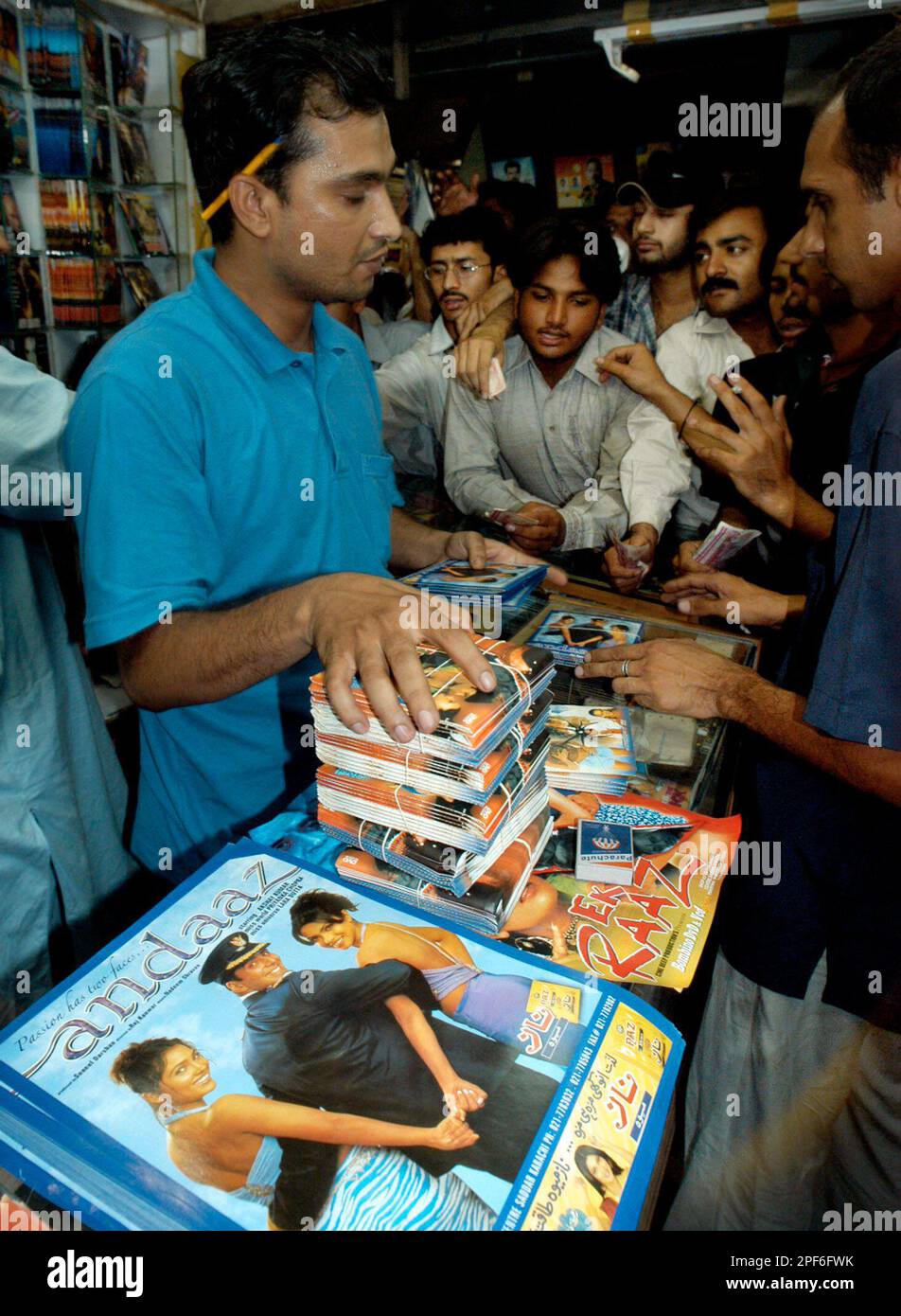 Pakistani customers buy CDs of newly released Indian feature film at a ...