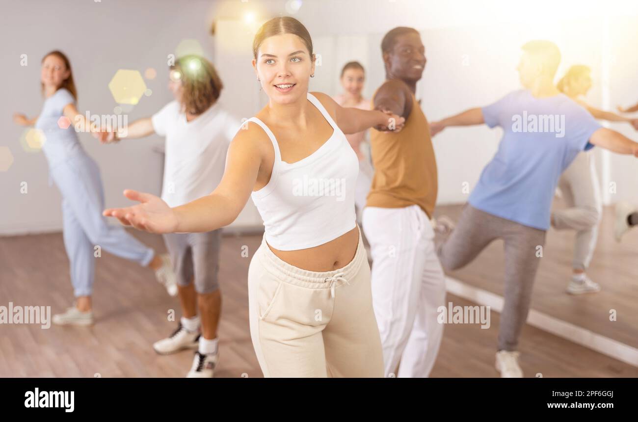 Group of positive smiling young adult people dancing in pairs during ...