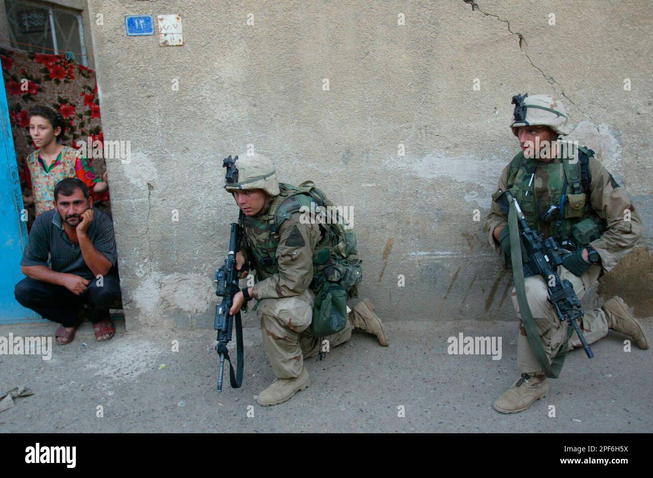 Woken up early in the morning by a raid, locals wait at their doorstep ...