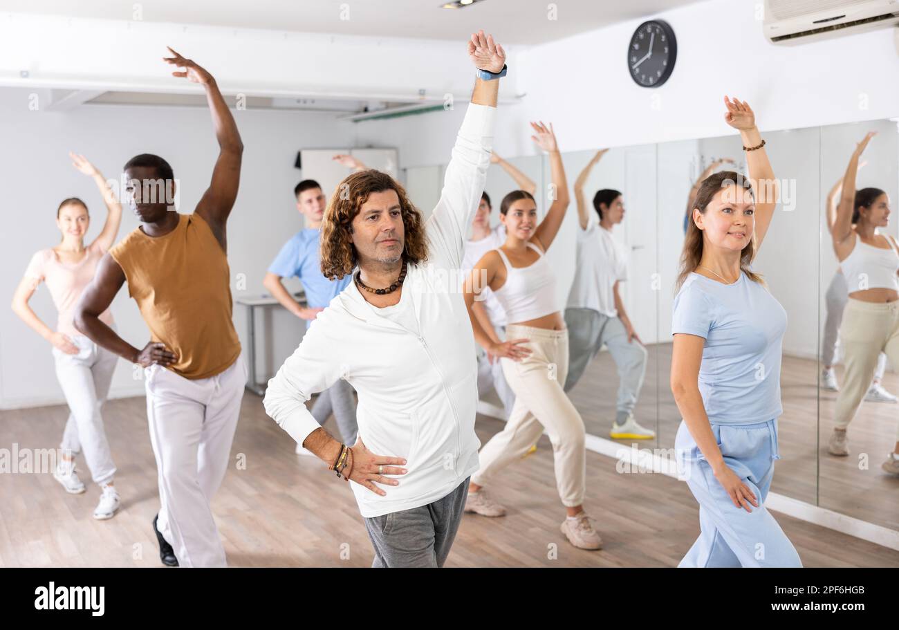Group of different people rehearsing dance in dance studio Stock Photo ...