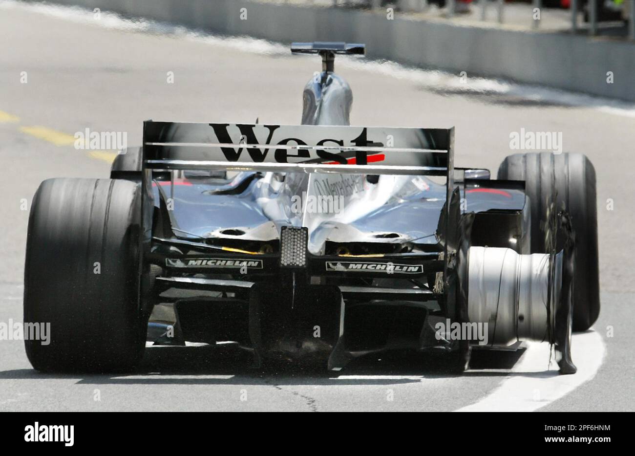 Kimi Raikkonen of Finland rolls into the pit after blowing a tire at ...