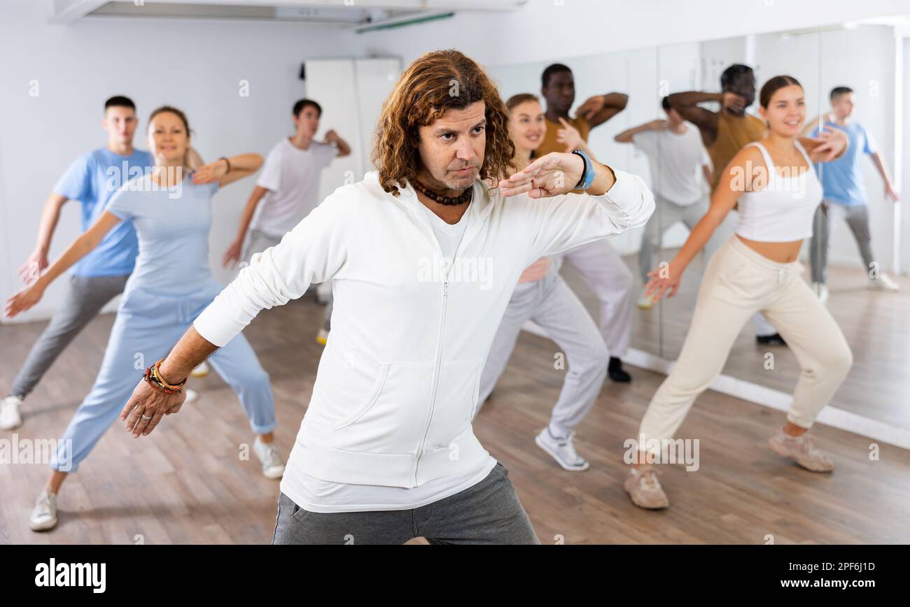 Group of different people rehearsing dance in dance studio Stock Photo ...