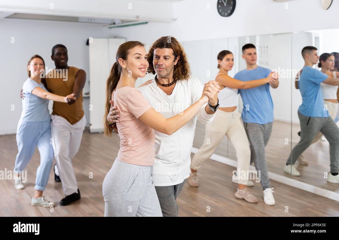 Man and woman in pairs learning to dance waltz in studio Stock Photo ...