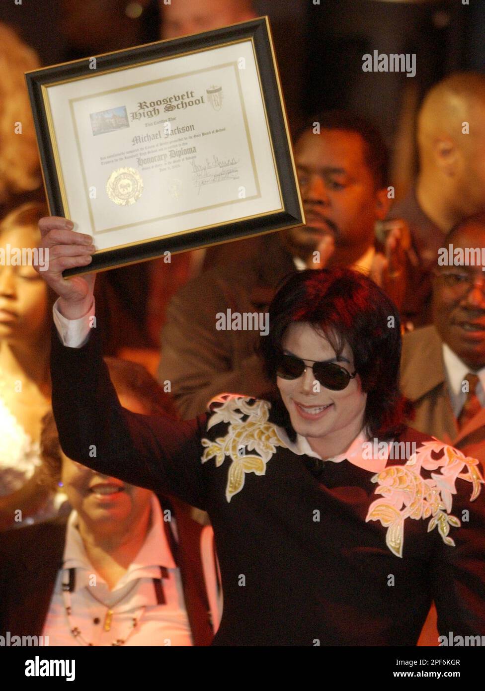 Michael Jackson holds up an honorary diploma given to him by Roosevelt ...