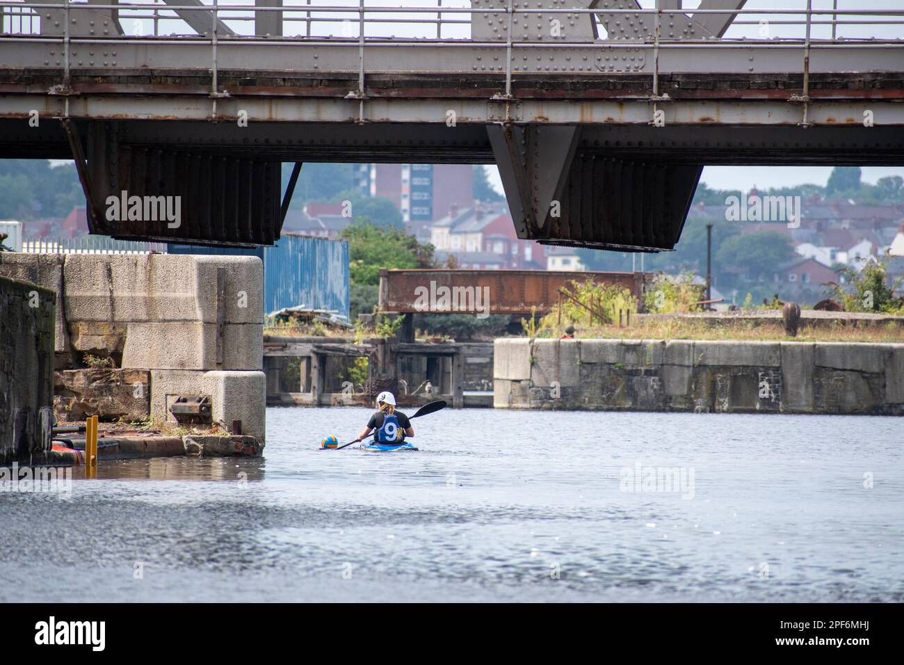 Young woman kayaking in Stanely Dock, Liverpool, with the bascule ...